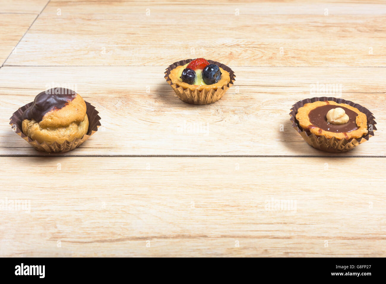 Pictured pastries on light wood background Stock Photo - Alamy
