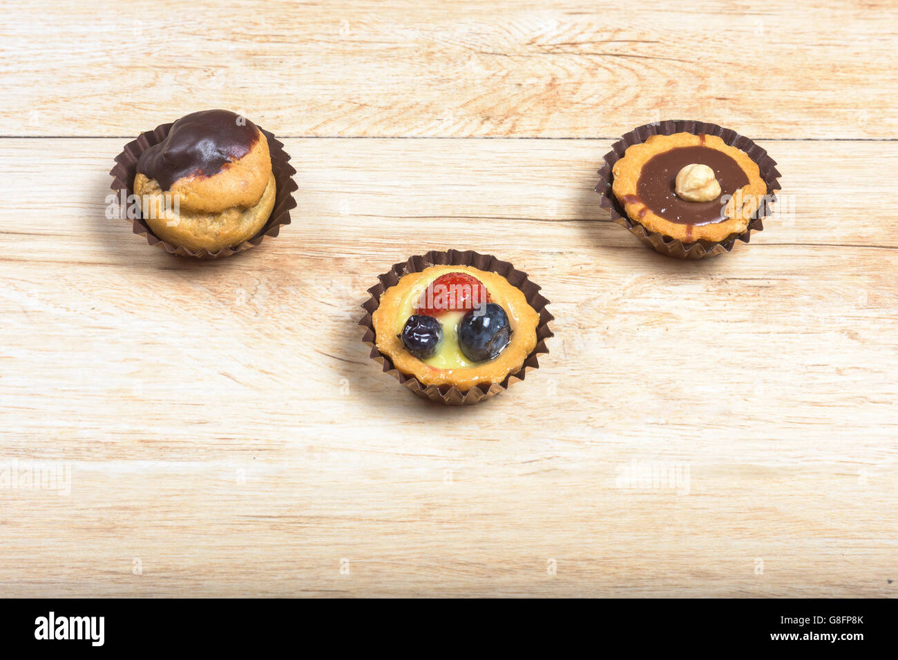 Pictured pastries on light wood background Stock Photo - Alamy