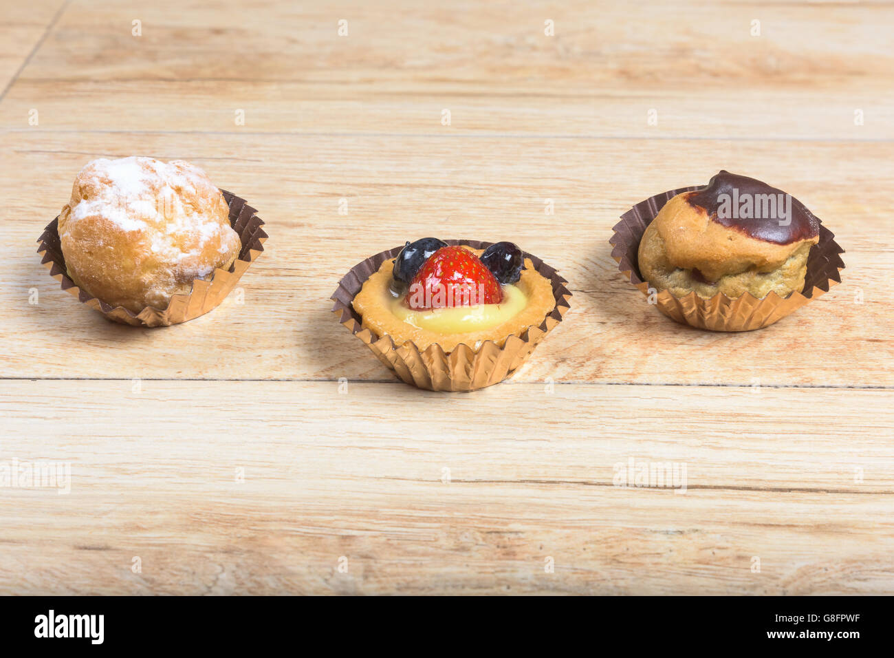 Pictured pastries on light wood background Stock Photo - Alamy