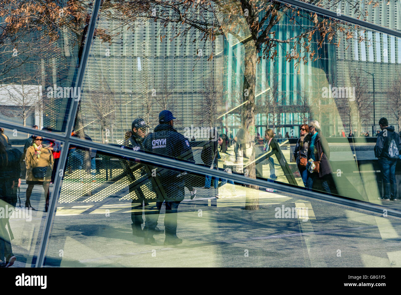 Two police officers are reflected in the glass of a building at ground ...
