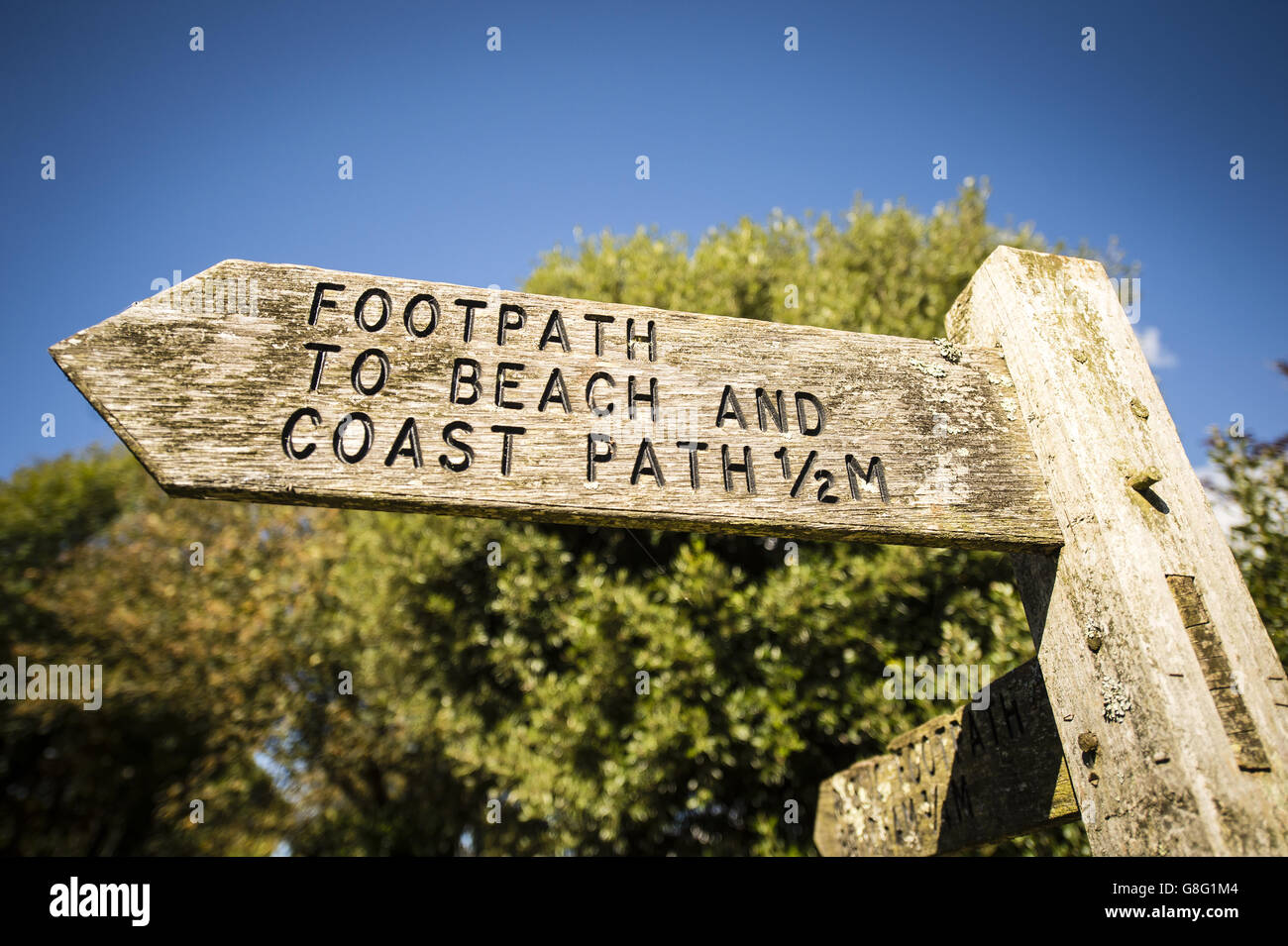A wooden sign to the beach and coast path in the village of Thurlestone ...