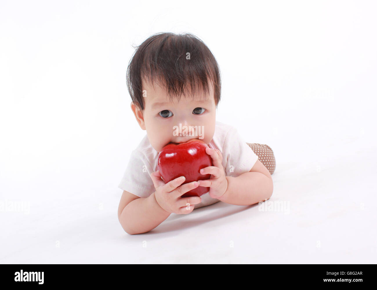 Cute baby with red apple (eating healthy food) on white background ...