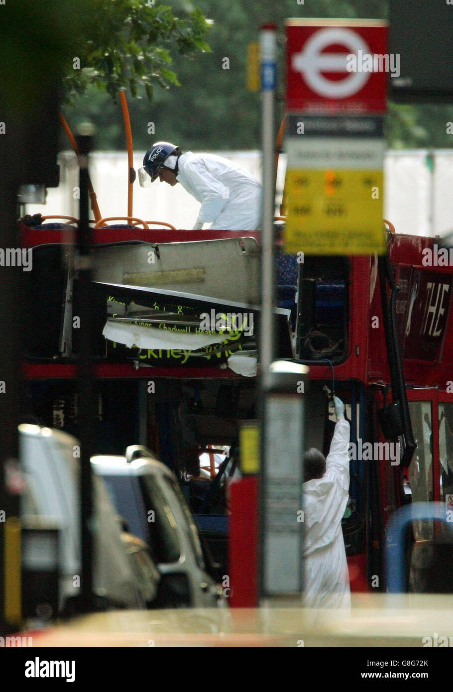 A police officer stands on what remains of the top deck of the number ...