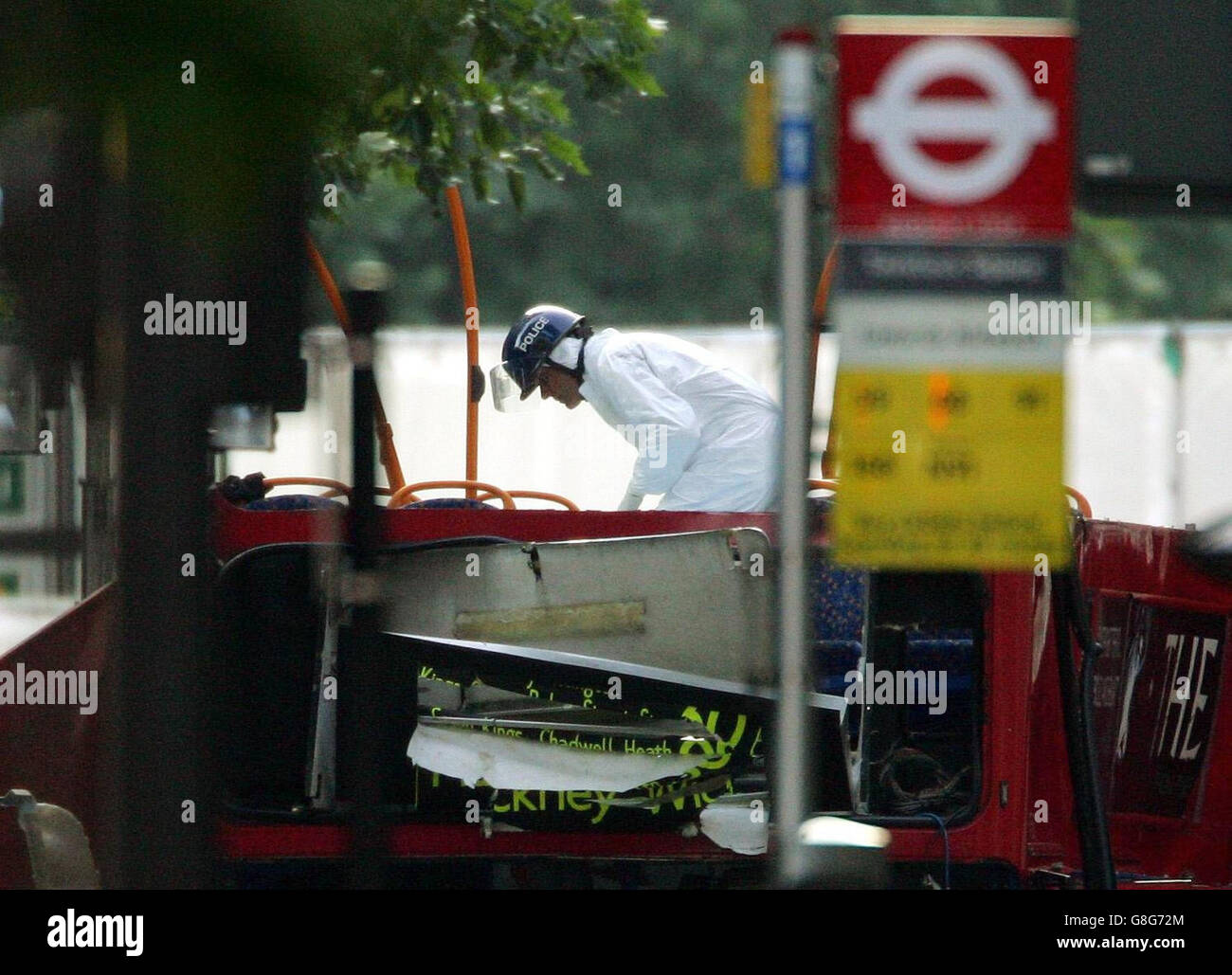 A police officer stands on what remains of the top deck of the number ...