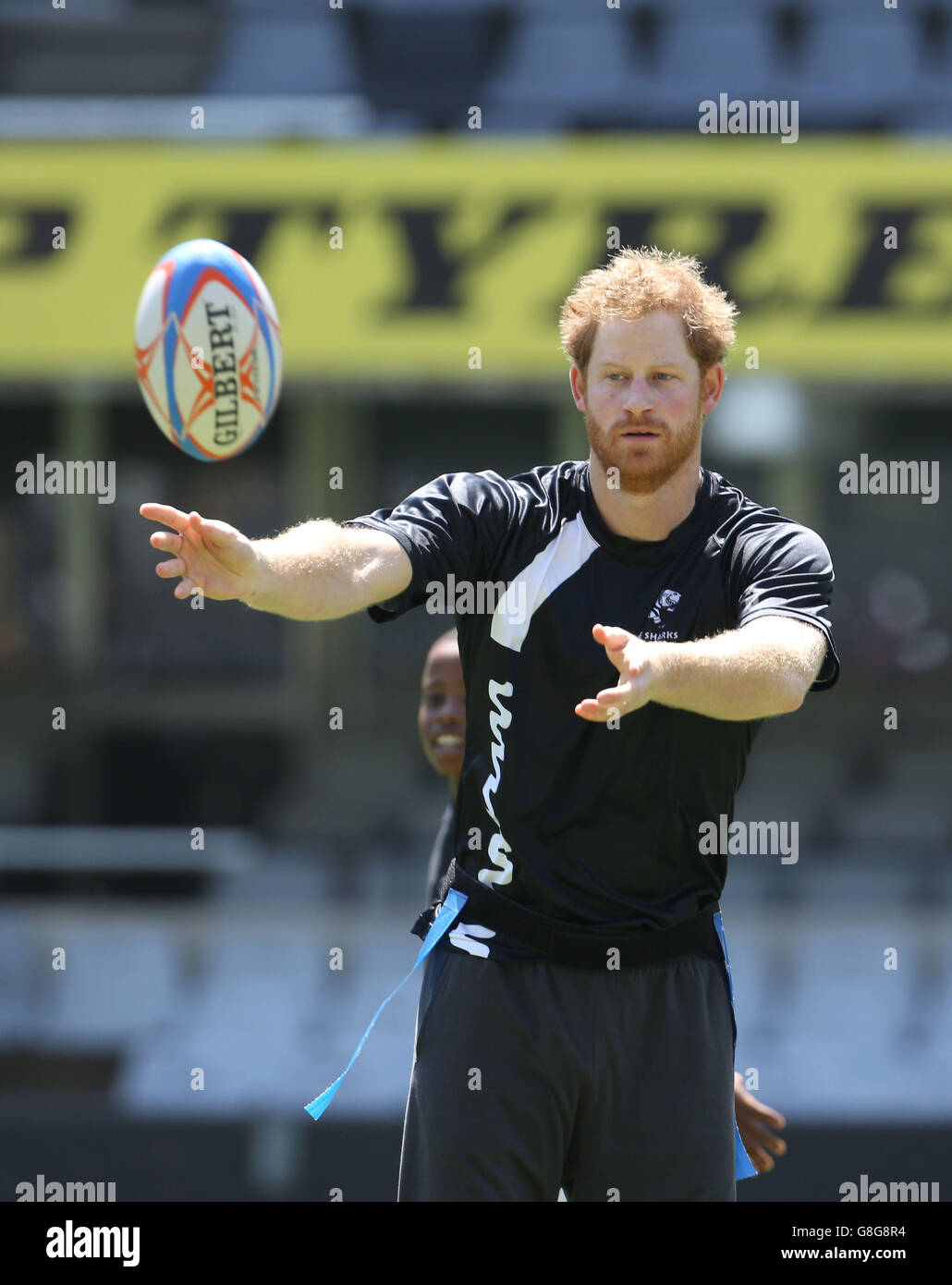 Prince Harry playing tag rugby with children at Kings Park Stadium as ...