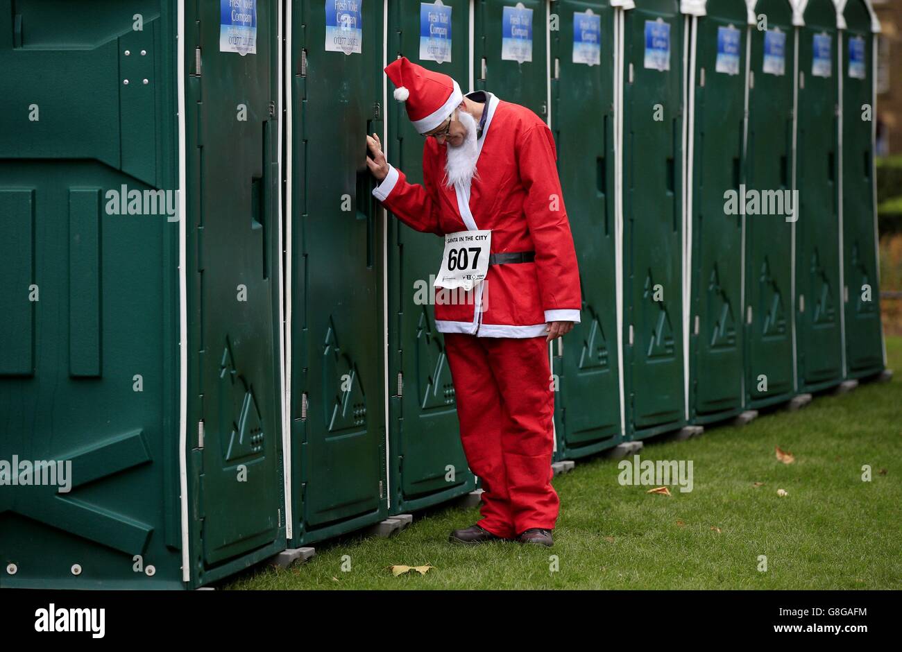A participant in the London Santa Run, waits to use a temporary toilet ... A participant in the London Santa Run, waits to use a temporary toilet ...