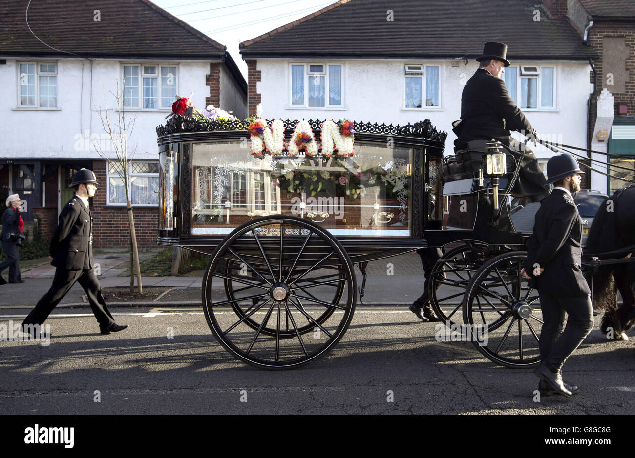A horse drawn hearse, escorted by actors dressed as policeman, carries ...