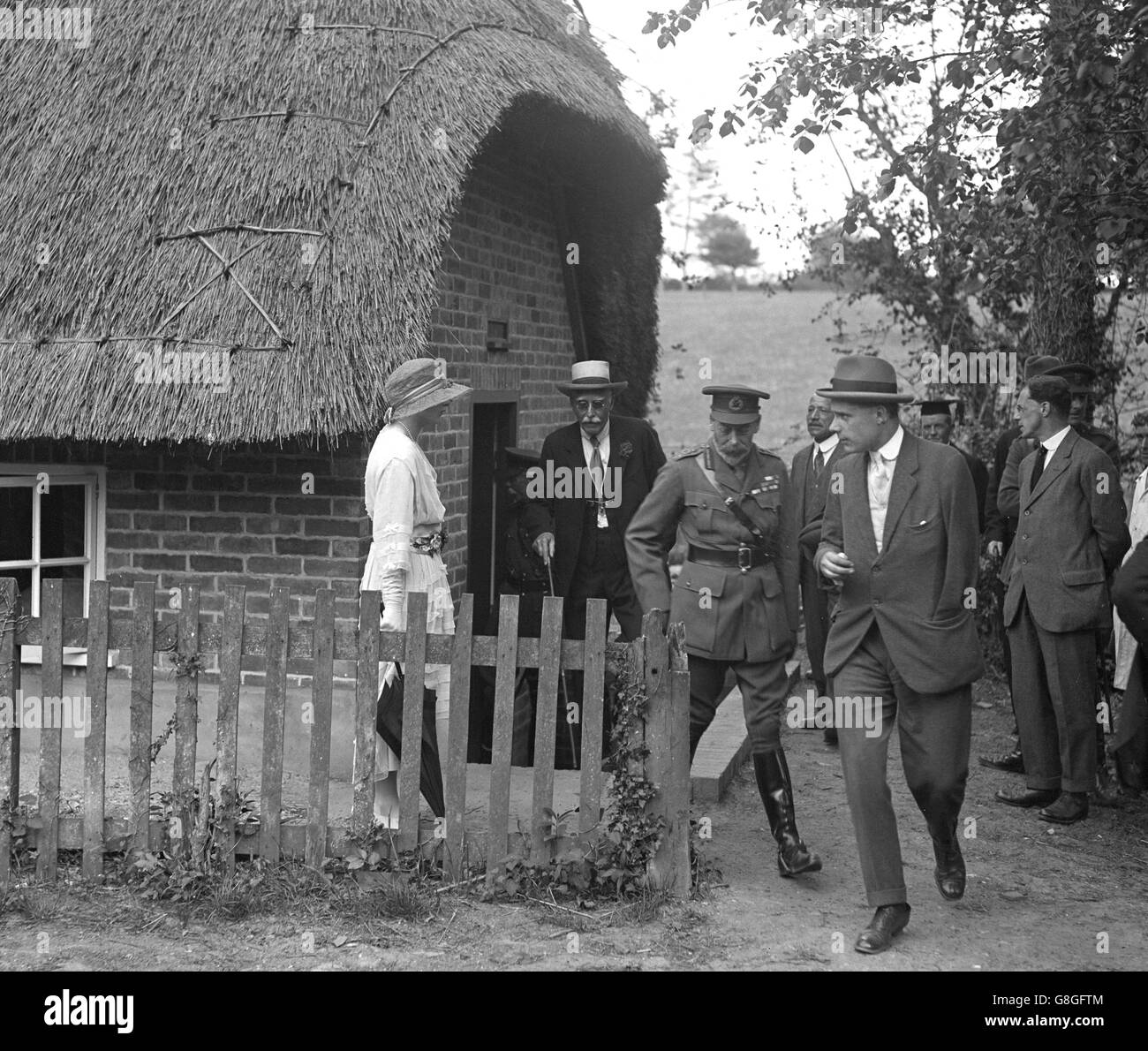 King George V leaves a cottage during his visit to a centre for ...