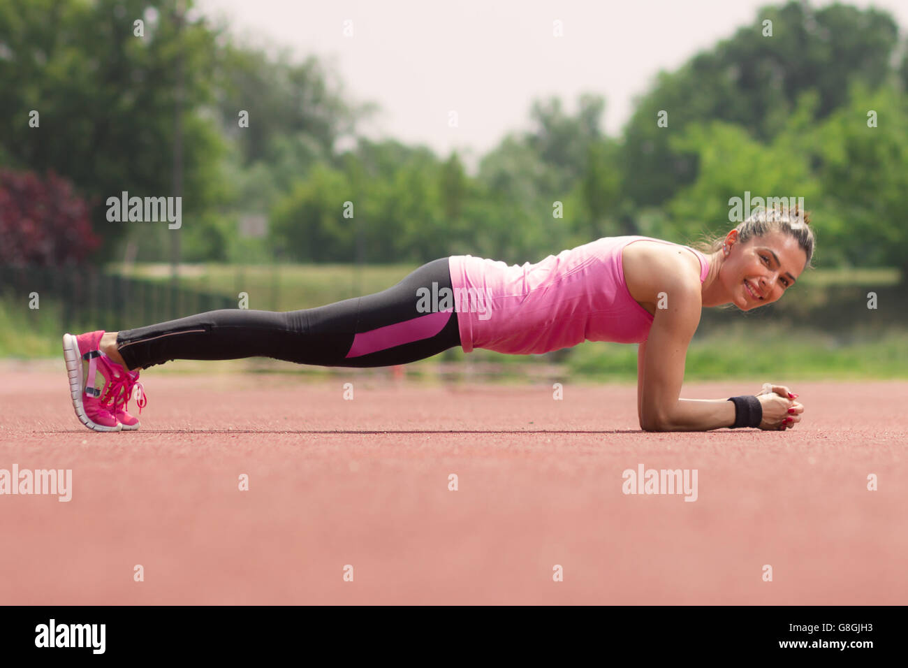 Side view, happy smiling, girl plank outdoors Stock Photo - Alamy