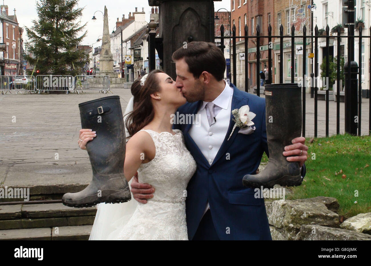 Lucy and Peter Nickson kiss while holding wellington boots outside ...