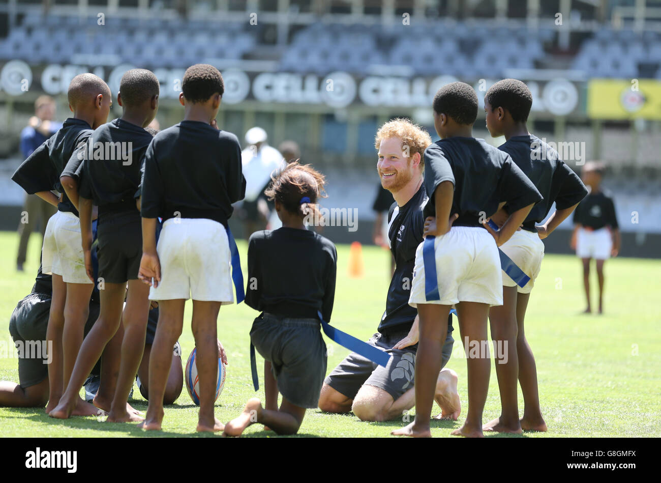 Prince Harry playing tag rugby with children at Kings Park Stadium as ...