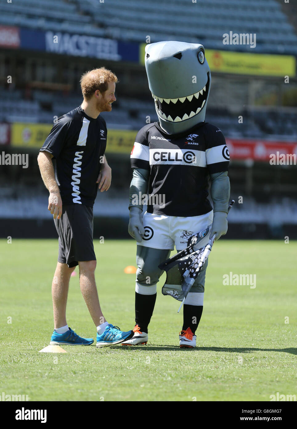 Prince Harry meets the mascot Sharkie as he walks onto the pitch at ...