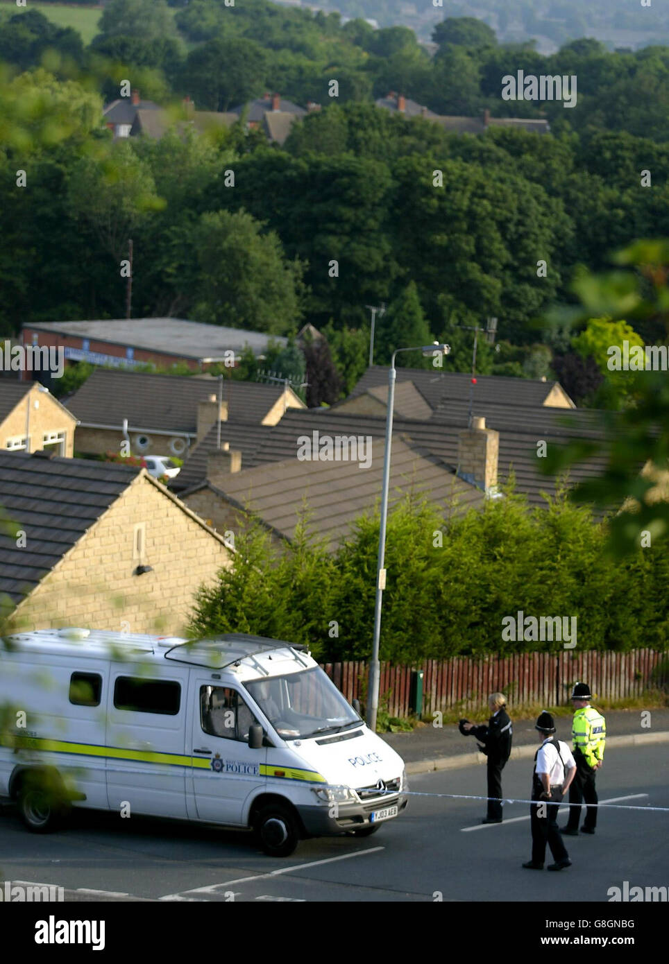 Police officers seal off the end of the road near the scene of an ...