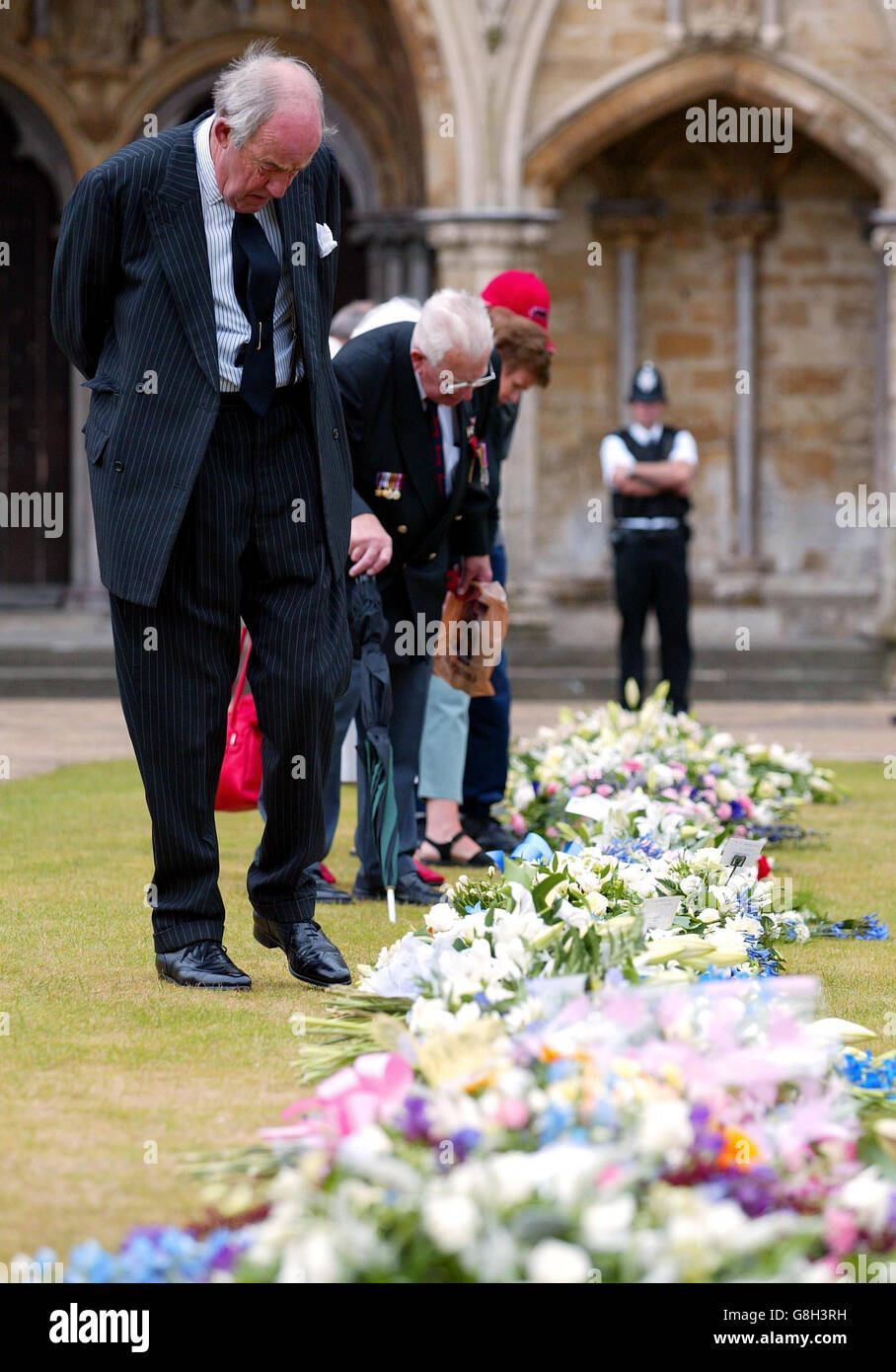 A Police officer watches over mourners before the funeral of Sir Edward ...