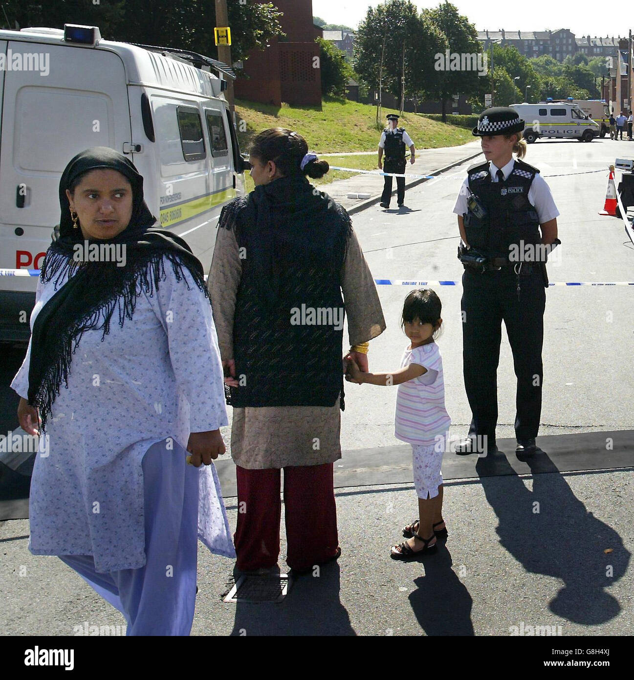 A police officer manning a cordon talks to local people unable to ...