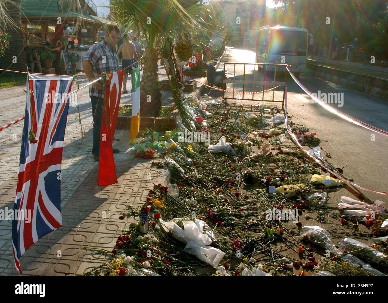 A man observes the scene of the bomb blast complete with flowers and ...