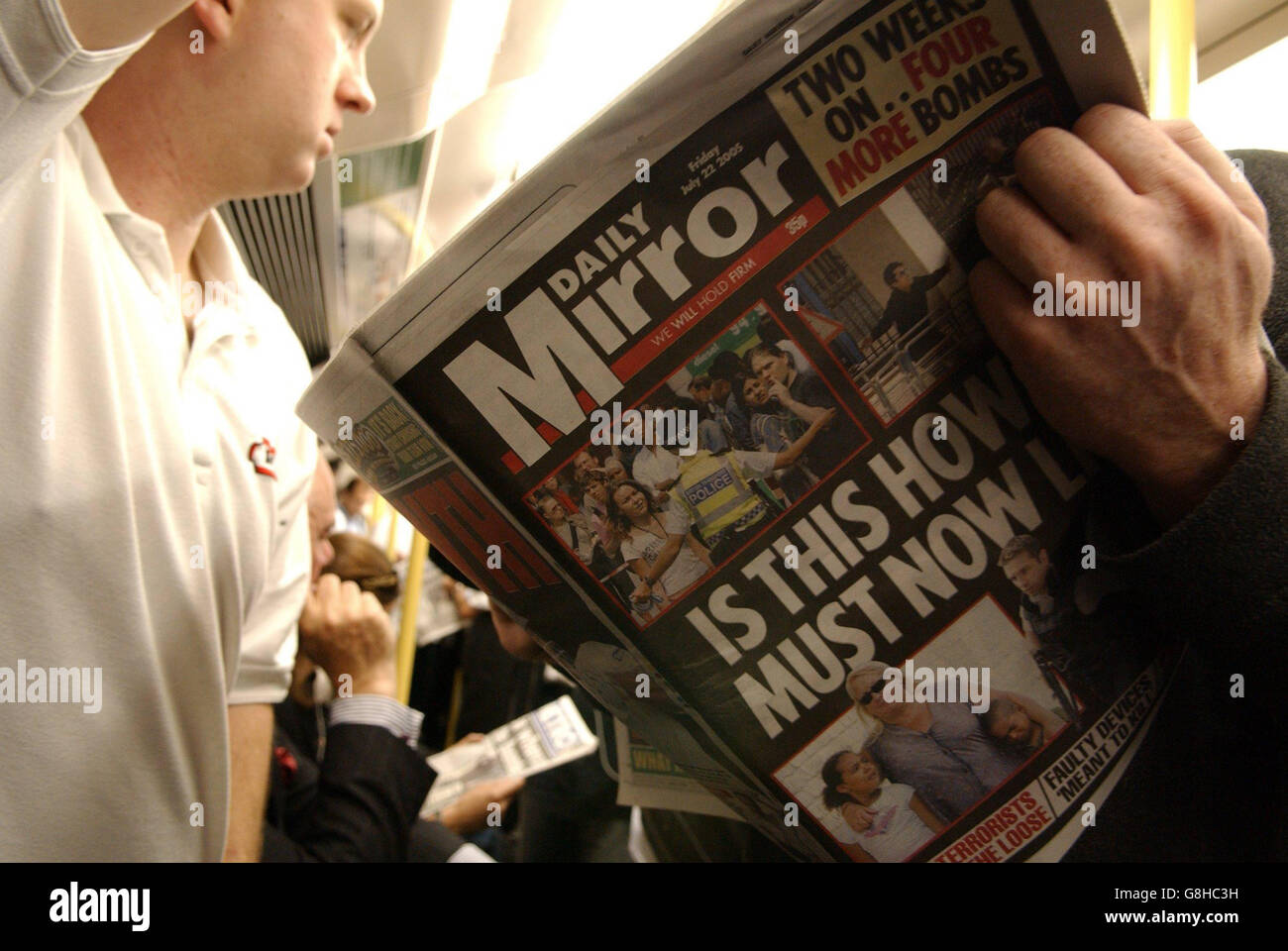 Commuters on londons northern line read their newspapers hi-res stock ...