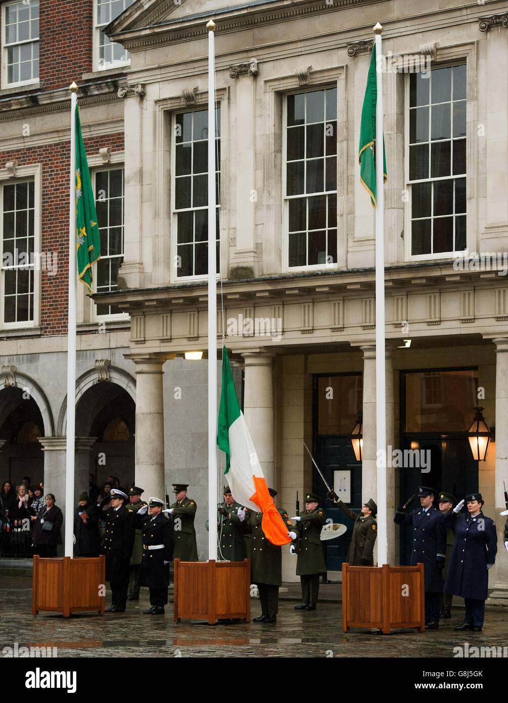 A member of the Irish defence forces holds the National Flag which was ...