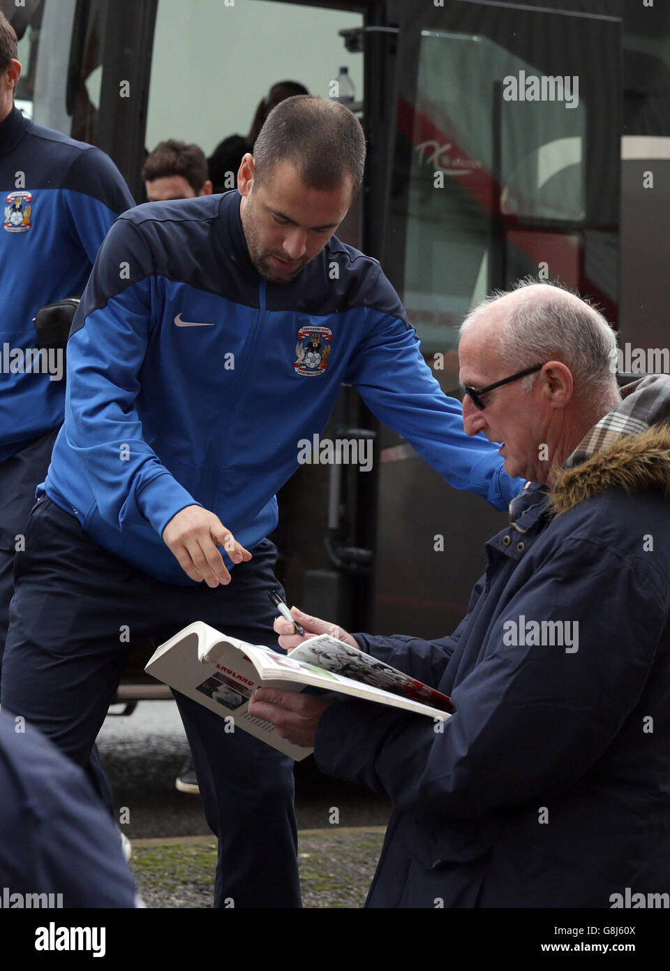 Coventry City's Joe Cole signs an autograph for a fan outside the ...