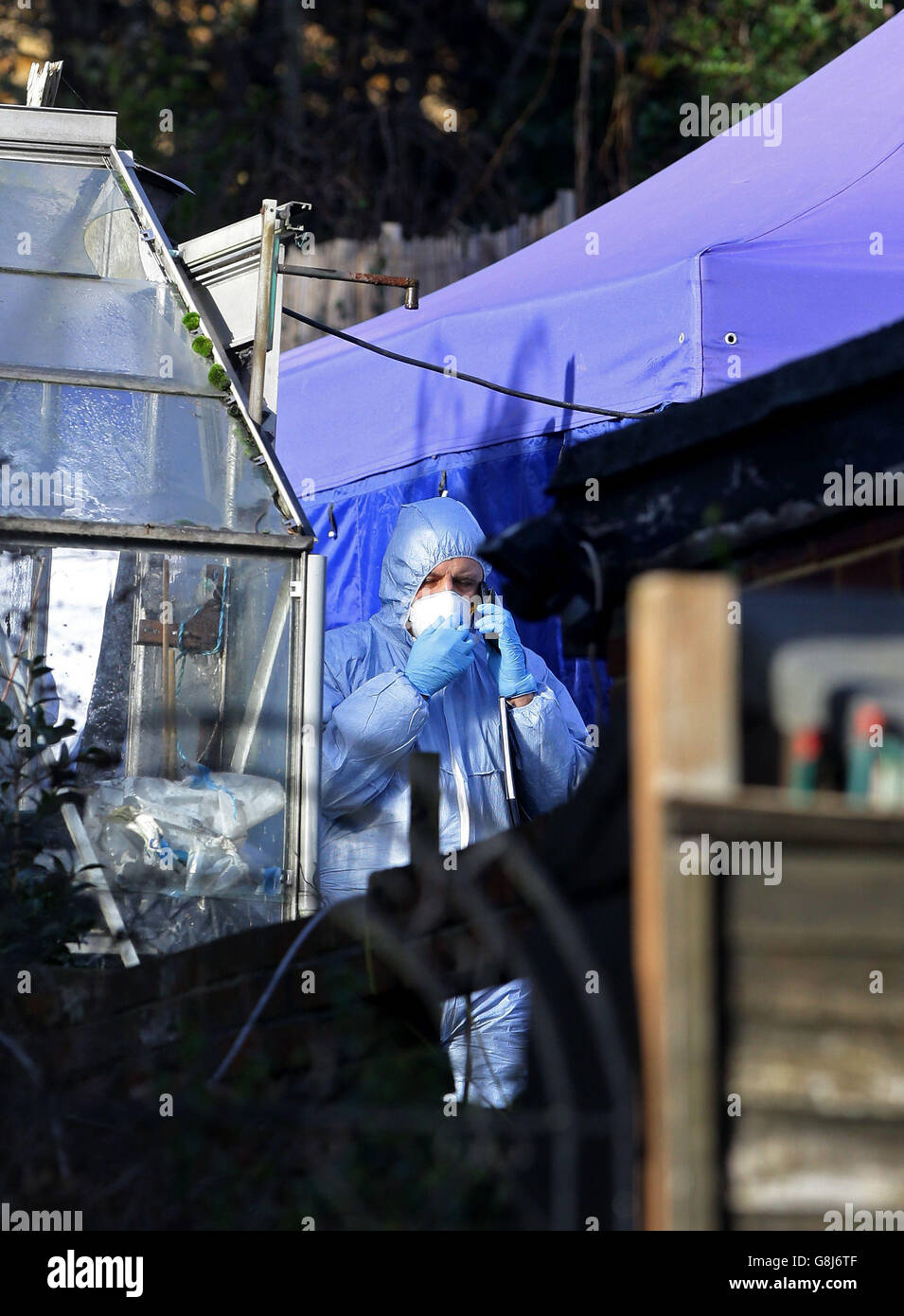 A police forensic officer in the back garden of the house in Erith ...