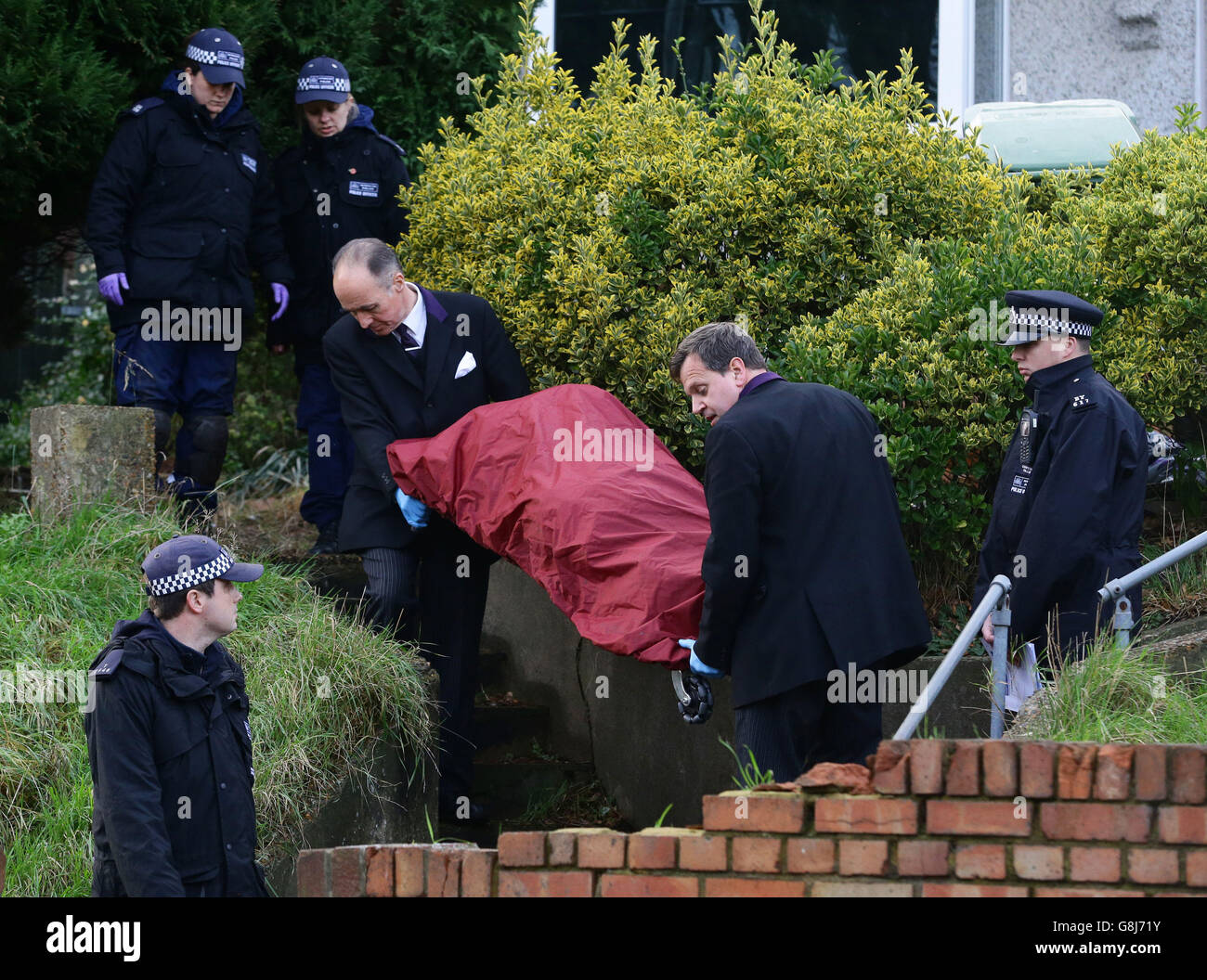 A body is removed from a house in Erith, Kent, which is being searched ...