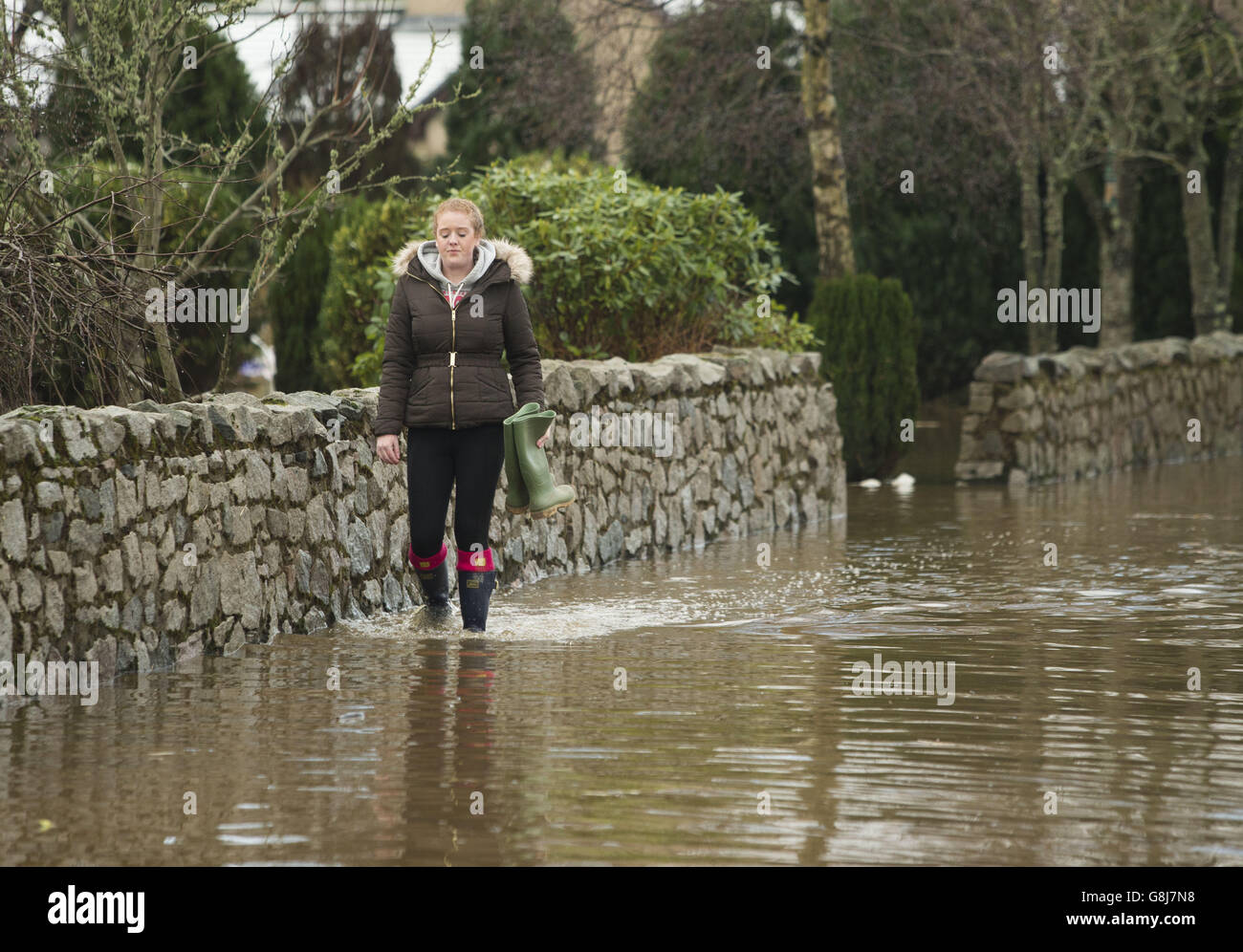 A woman walks through flood water in Port Elphinstone, near Aberdeen ...