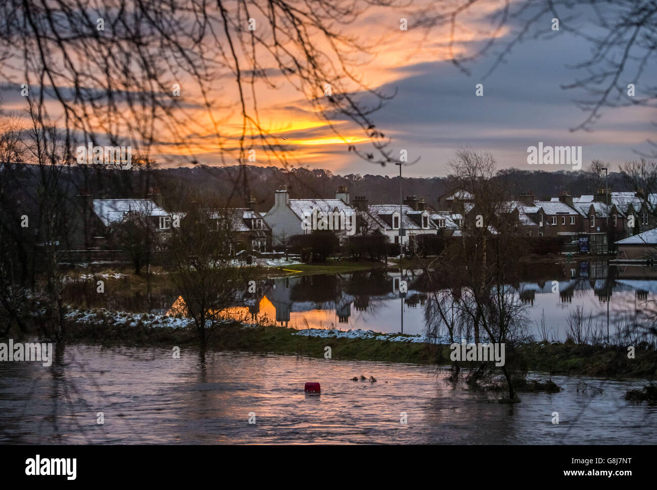 Houses are reflected in flood water at dawn in Port Elphinstone, near ...