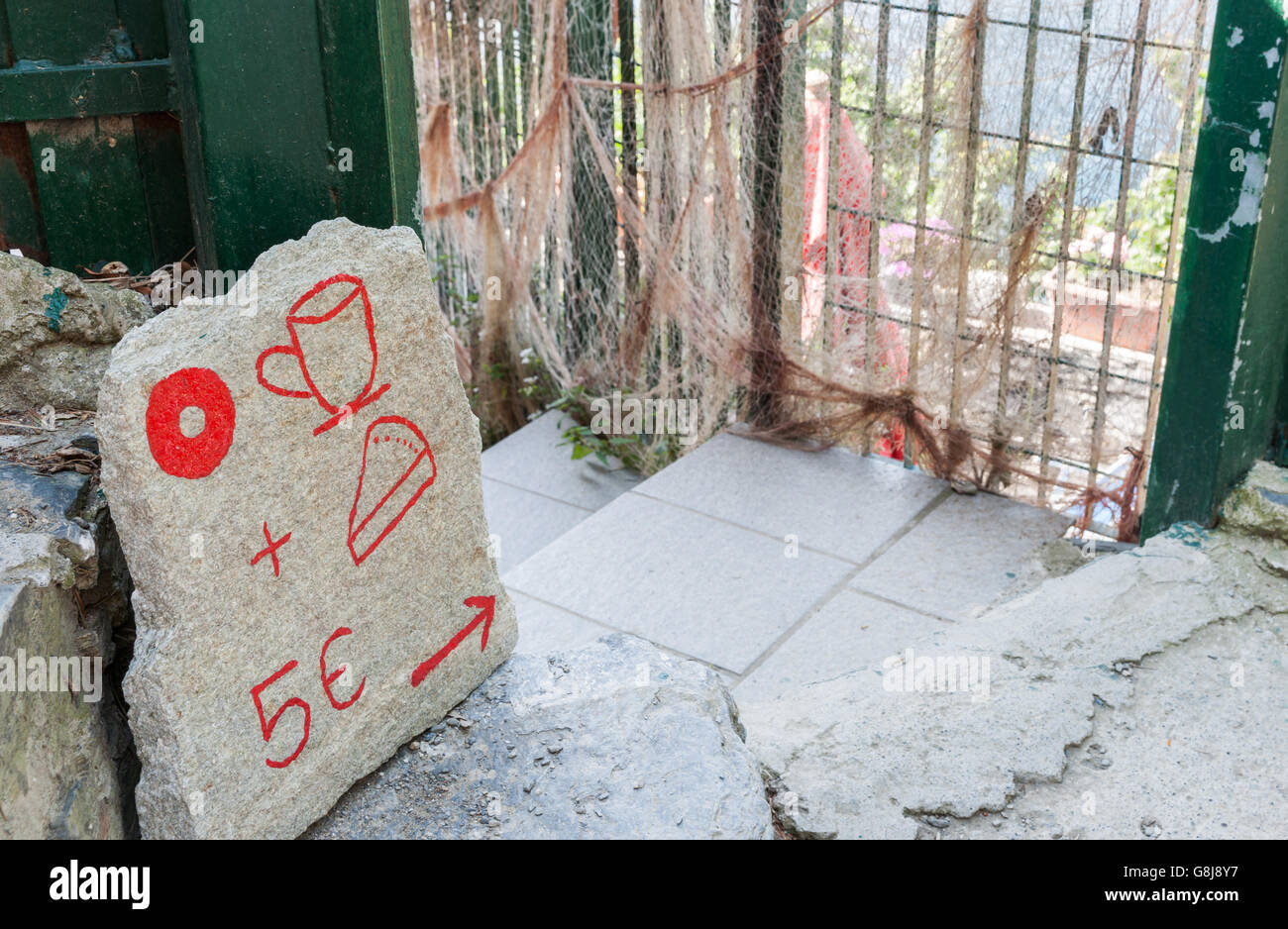 Coffee and cake five euro sign red lettering on slate rock at entrance ...