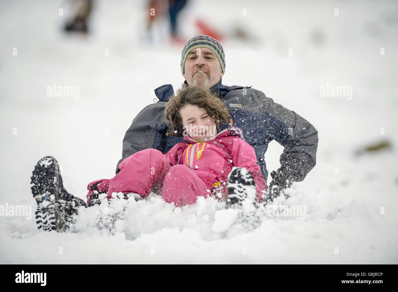 Matilda Davies, 6, from Cardiff and her father Paul, sledge in the snow ...