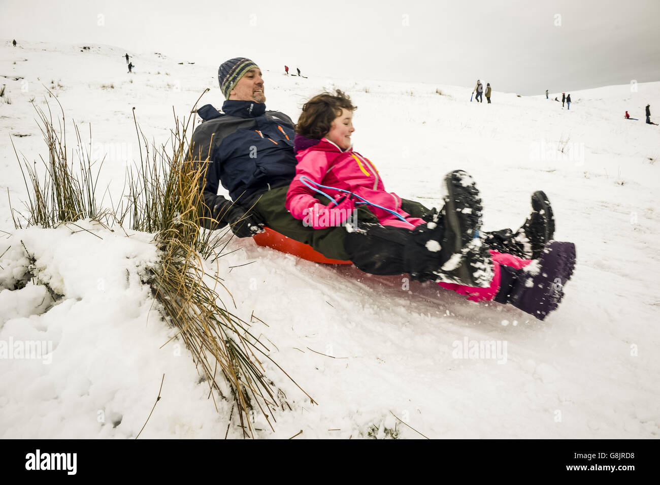 Matilda Davies, 6, from Cardiff and her father Paul, sledge in the snow ...