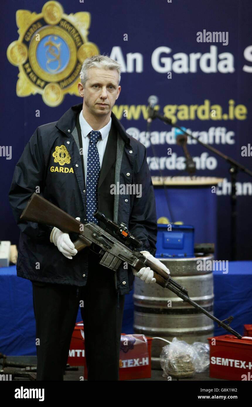 Detective Garda Shay O'Donnell holds an Ak-47 as samples of weapons ...