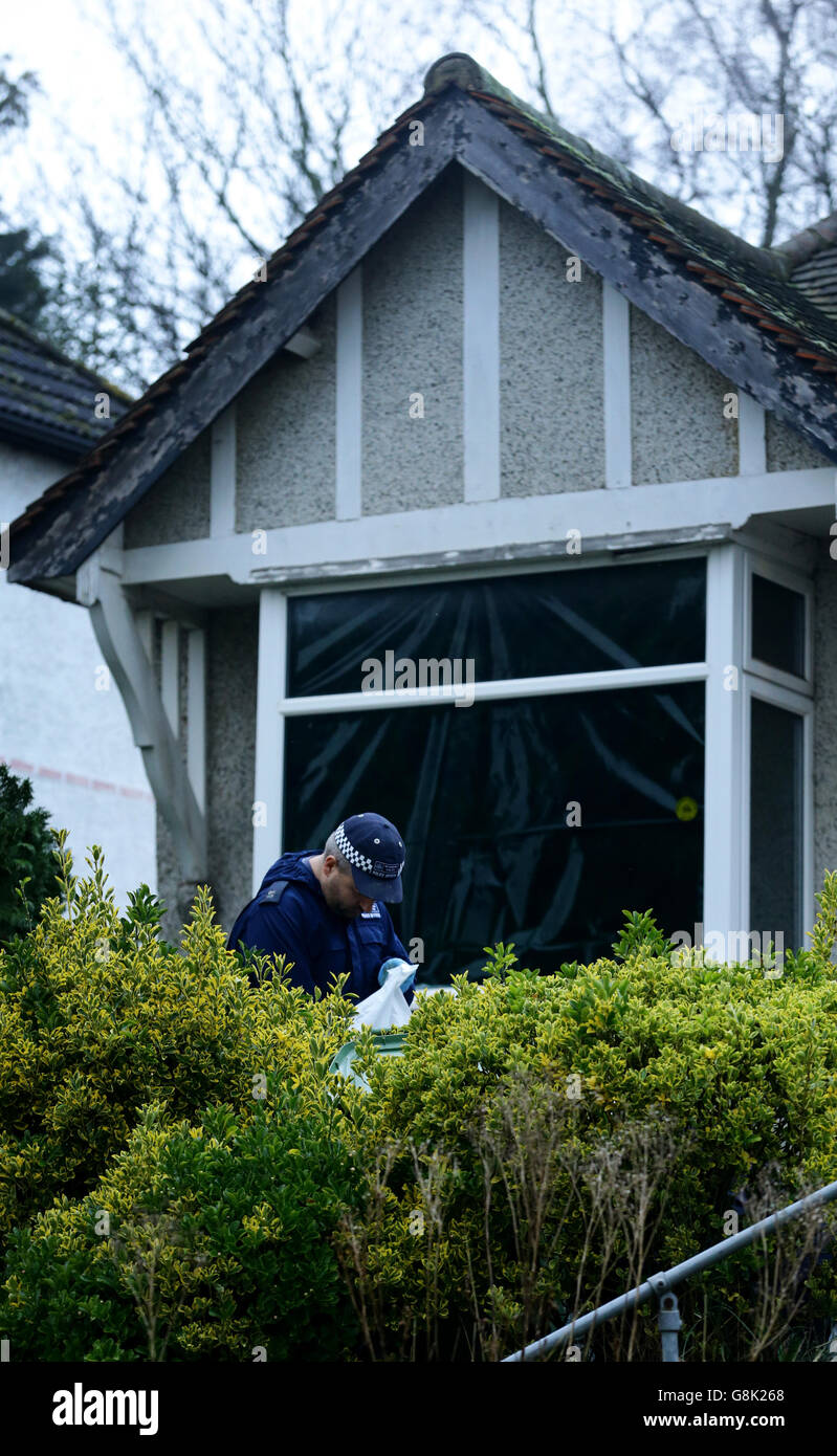 Police search officers investigate the front garden of the house in ...