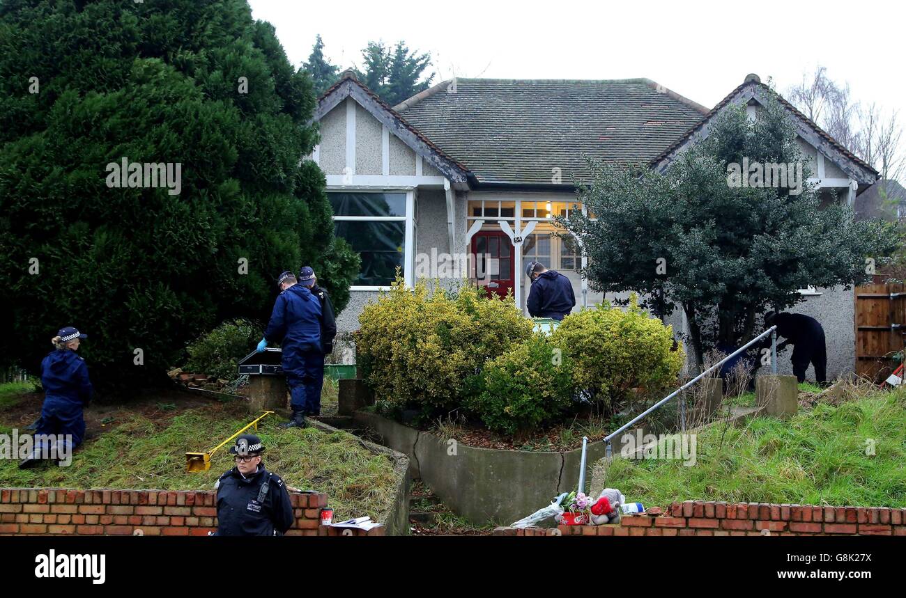 Police search officers investigate the front garden of the house in ...