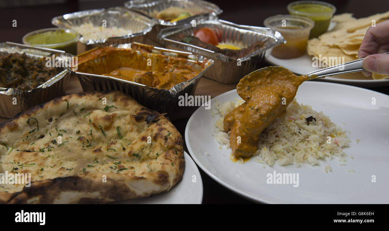 A chicken curry is served surrounded by Indian take away food Stock ...