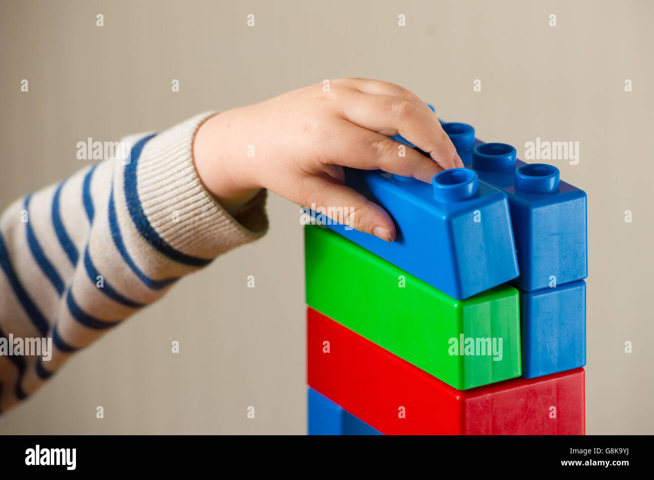 A preschool age child plays with plastic building blocks Stock Photo ...