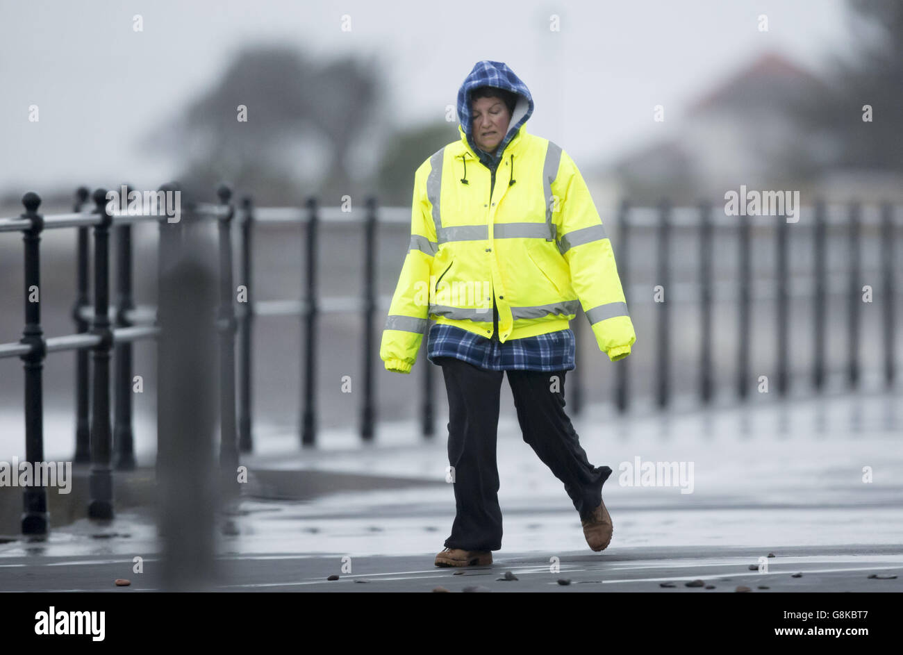 A woman walks along the sea front in Largs, Scotland, as Storm Gertrude ...