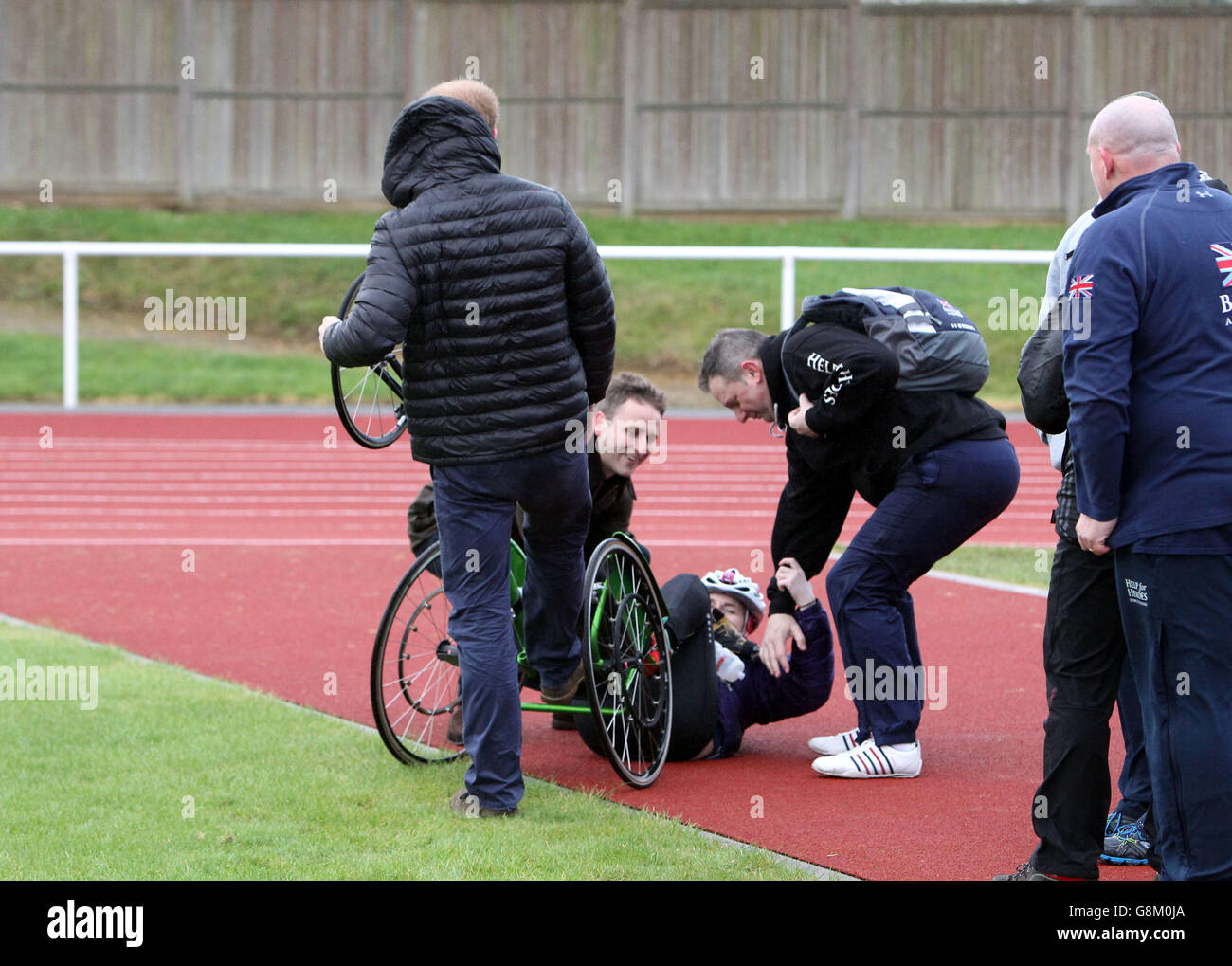 Prince Harry (left, back to camera) helps Anna Pollock after she fell ...