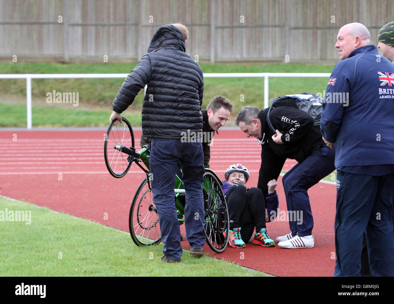 Prince Harry (left, back to camera) helps Anna Pollock after she fell ...
