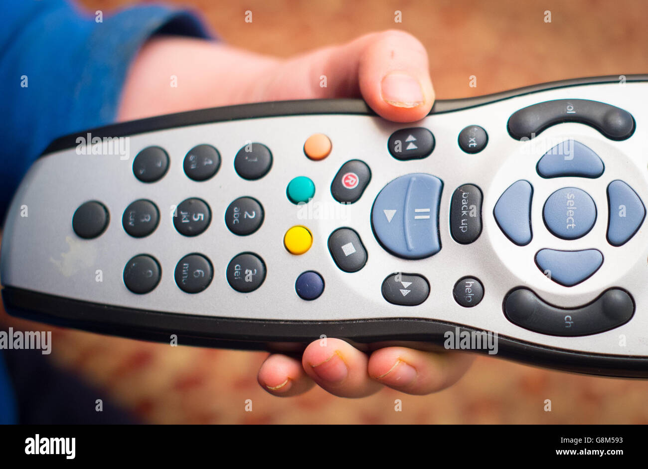 A child's hand holds a television remote control Stock Photo - Alamy