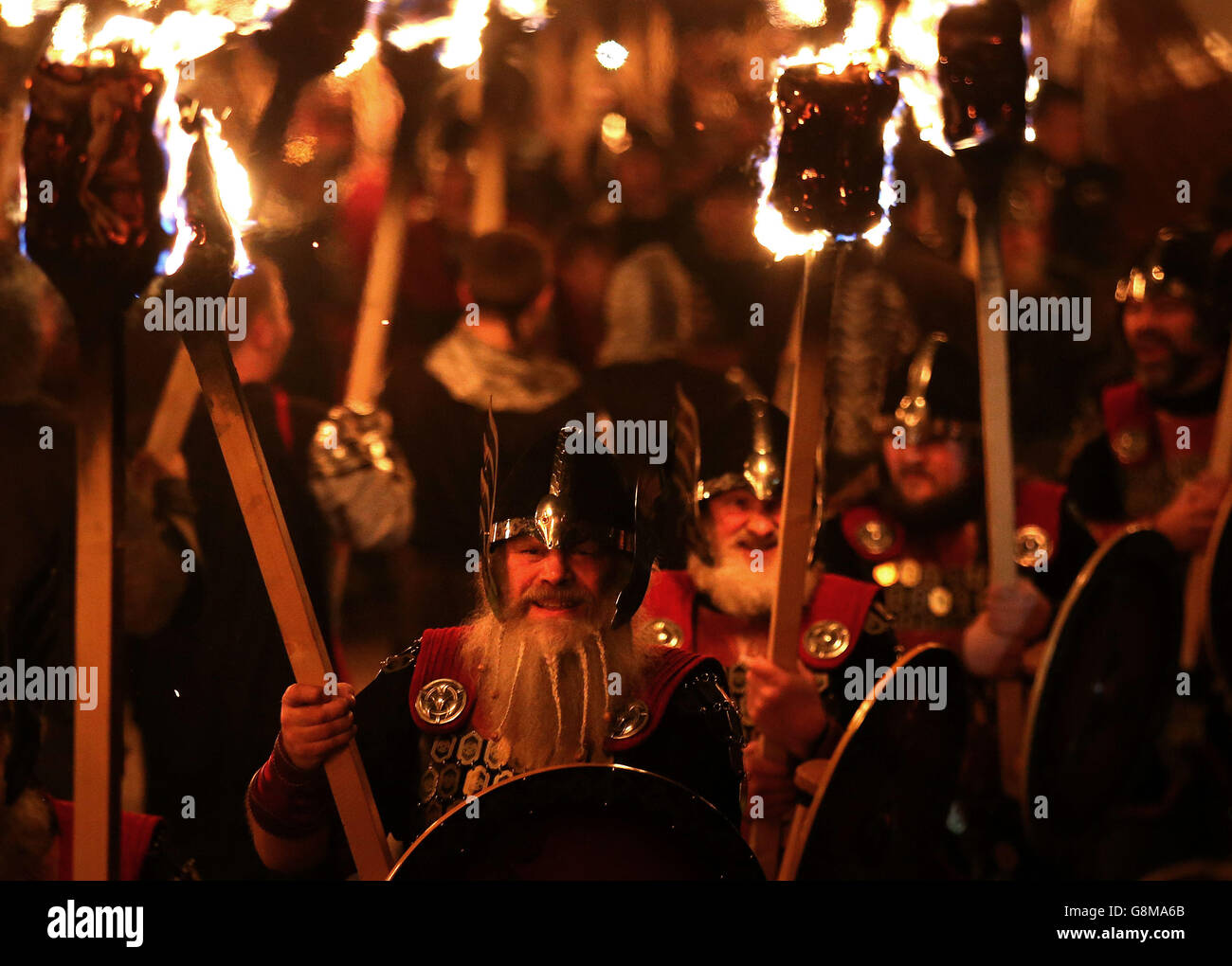 Members of the Jarl Squad dressed in Viking costumes carry flaming ...