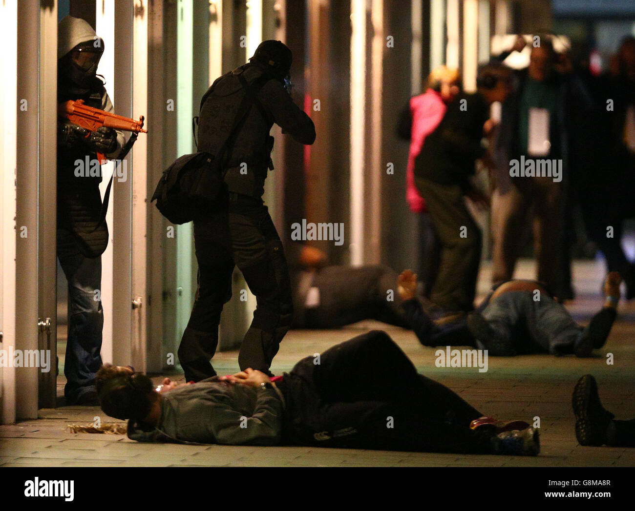 People playing the part of gunmen 'open fire' at a packed bus stop ...
