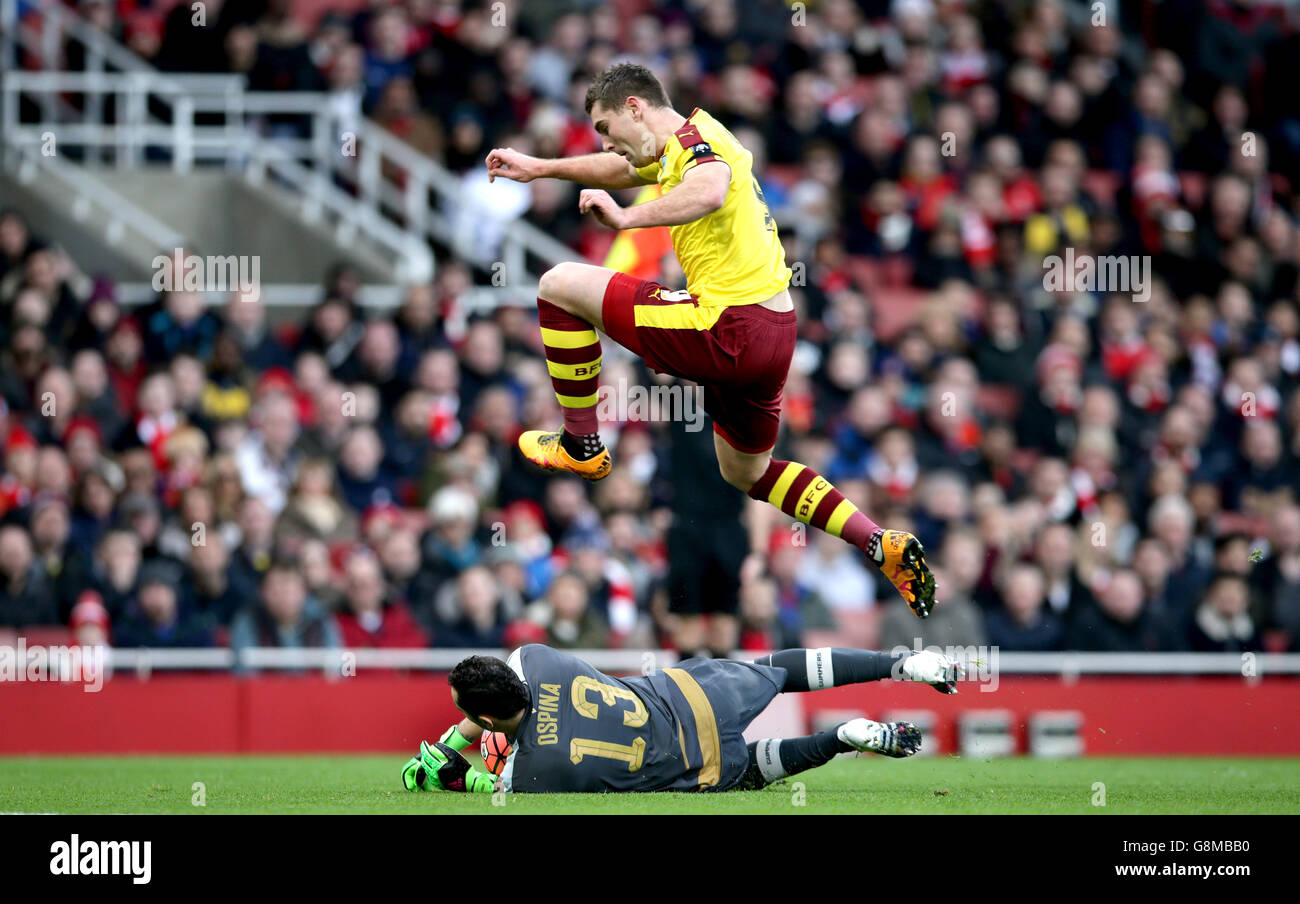 Burnley's Sam Vokes hurdles the challenge from Arsenal goalkeeper David ...