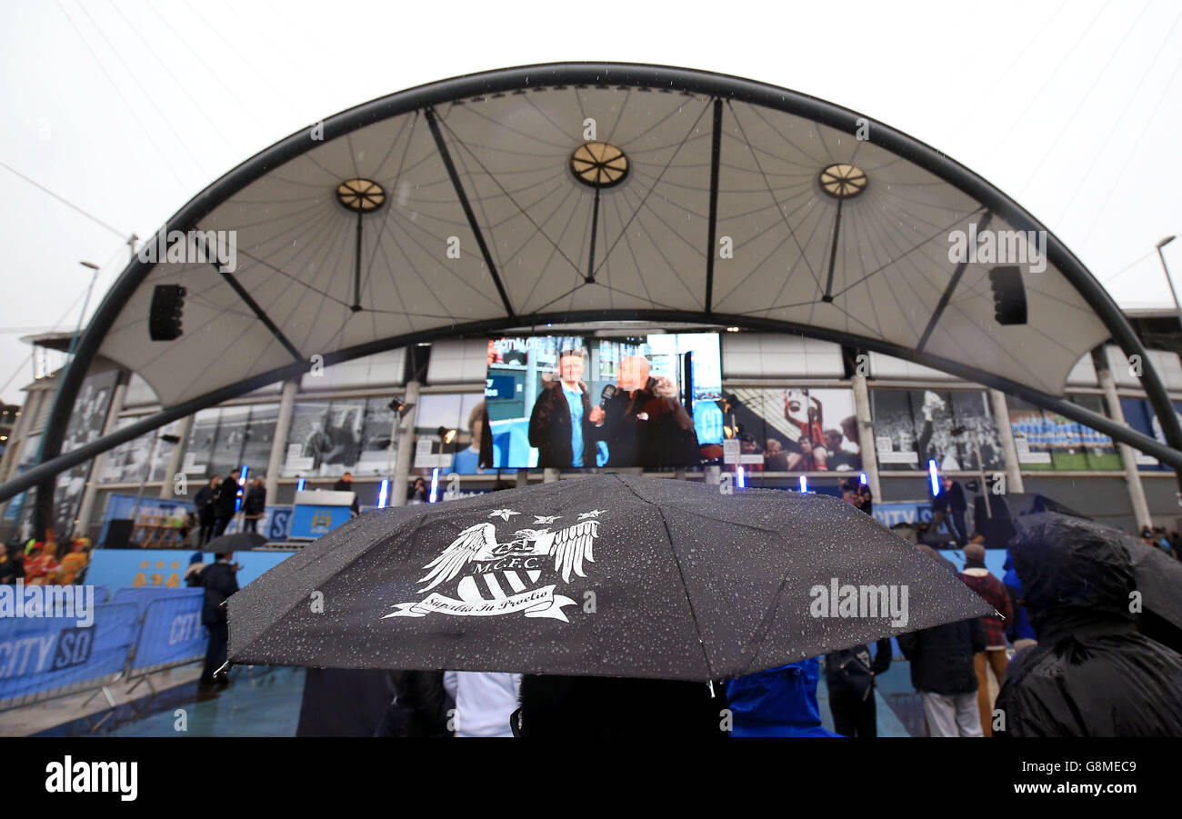 Supporters shelter from the rain under a umbrella in the Manchester ...
