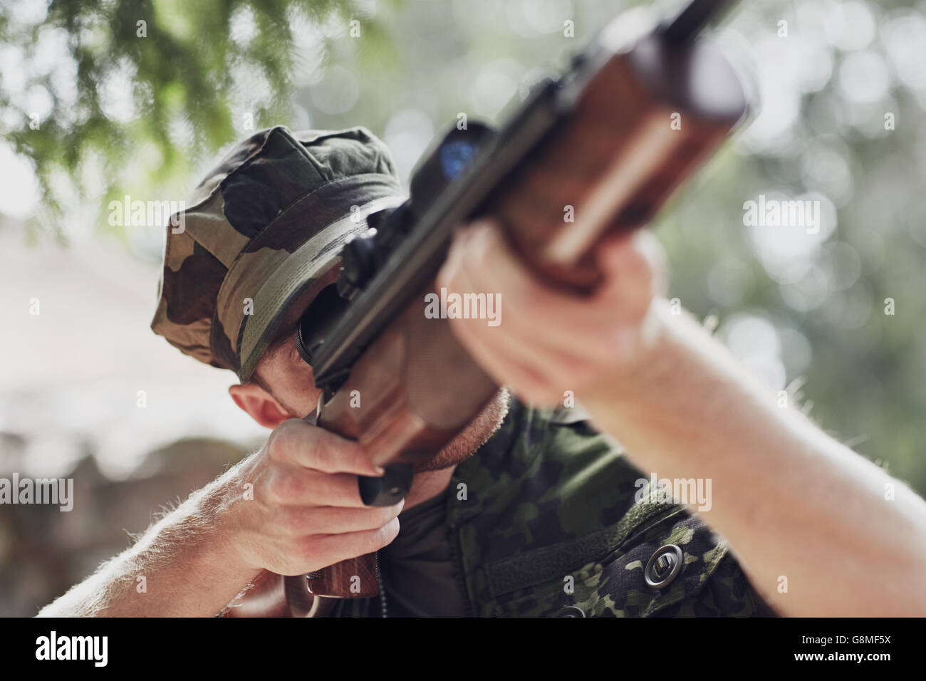 soldier or hunter shooting with gun in forest Stock Photo - Alamy