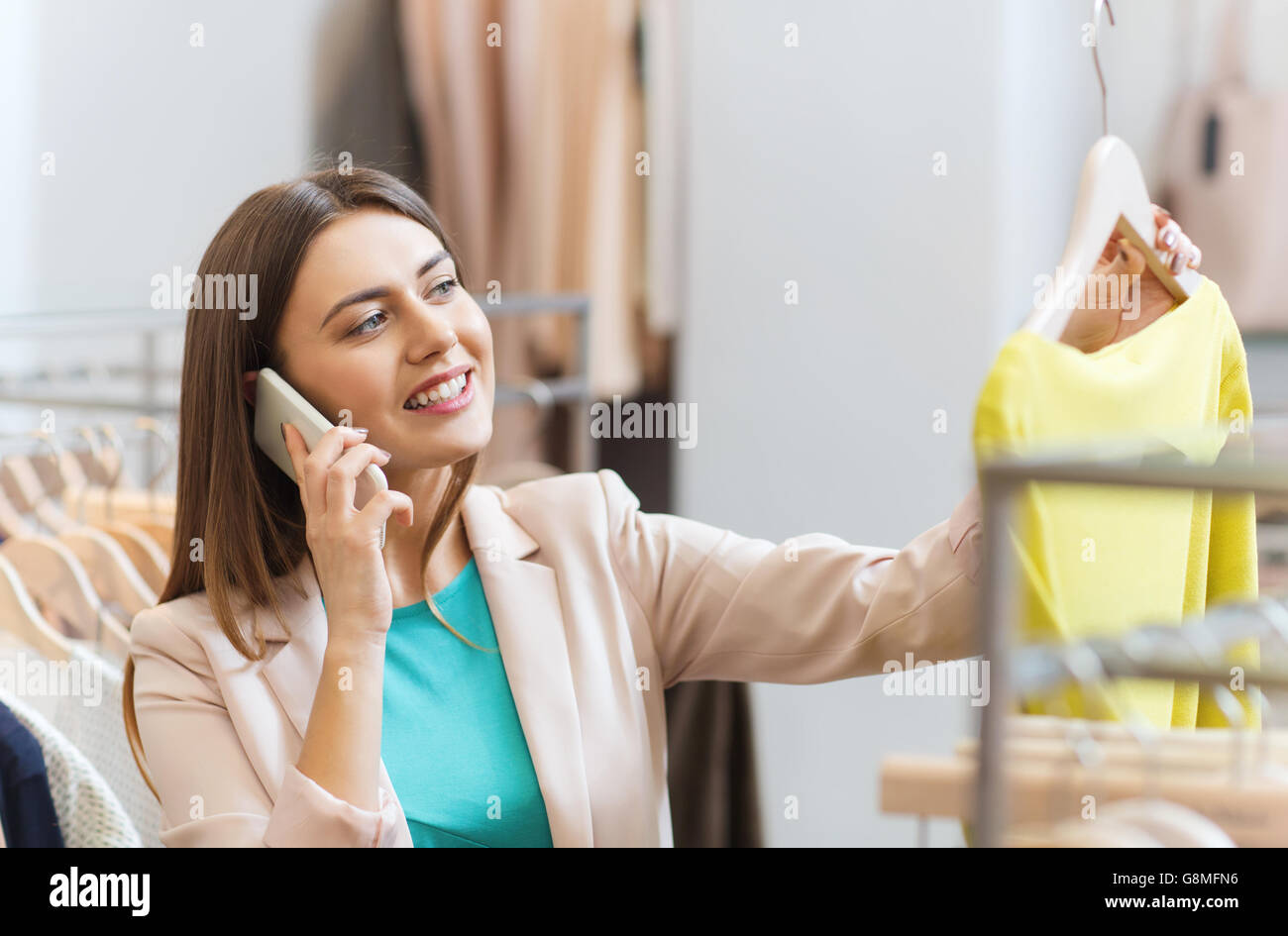 woman calling on smartphone at clothing store Stock Photo - Alamy