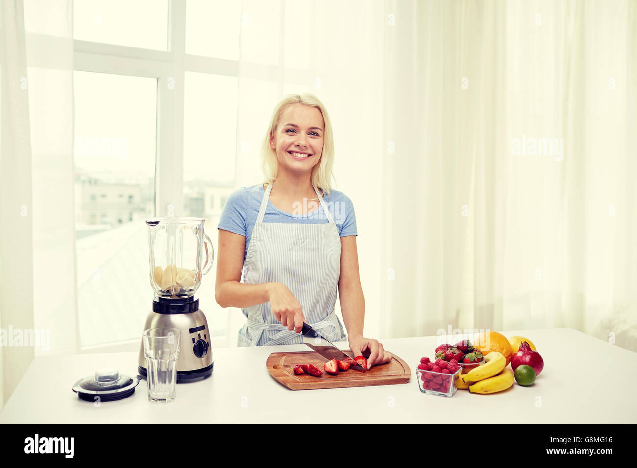 smiling woman with blender preparing shake at home Stock Photo - Alamy