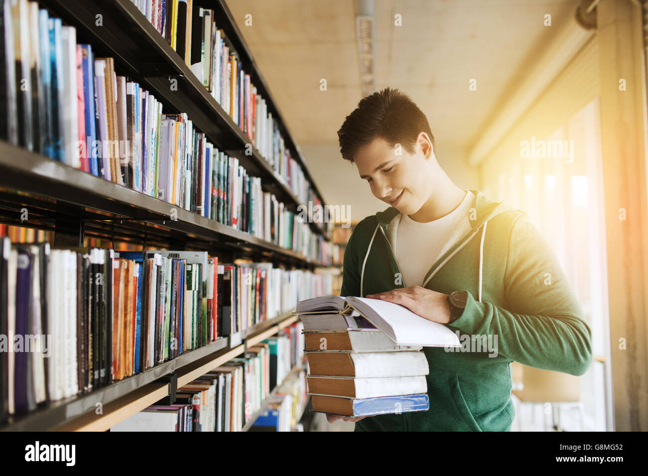 Student man holding book library smiling happy hi-res stock photography ...