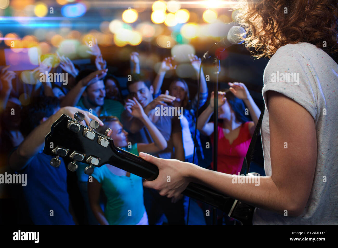 female singer playing guitar over happy fans crowd Stock Photo - Alamy