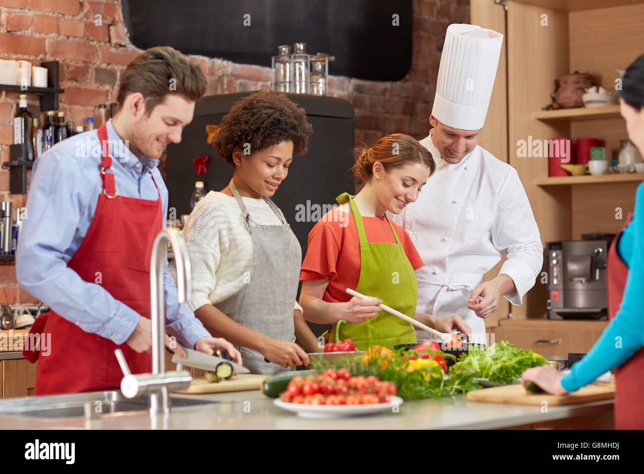 happy friends and chef cook cooking in kitchen Stock Photo - Alamy