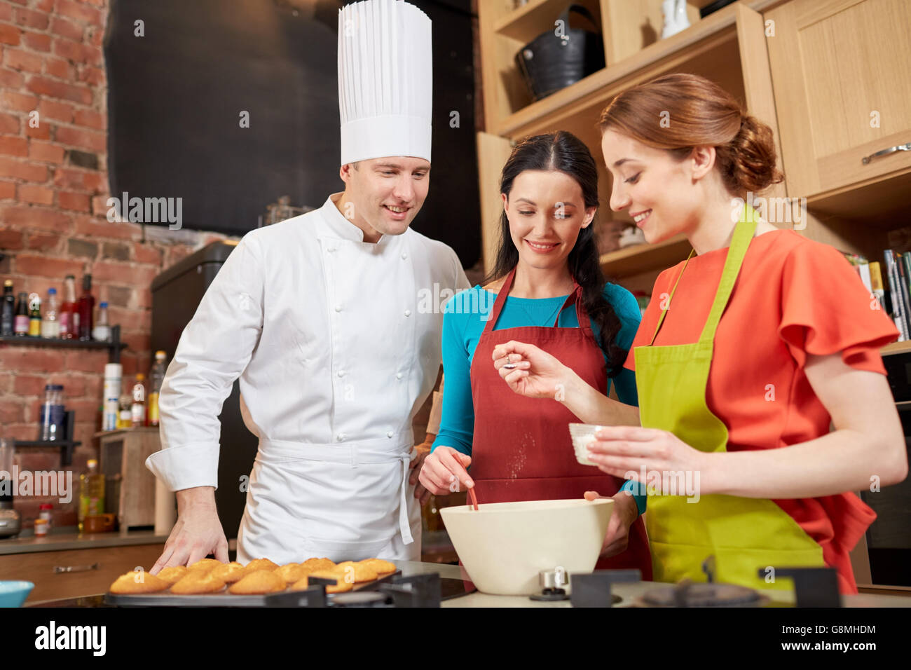 happy women and chef cook baking in kitchen Stock Photo - Alamy